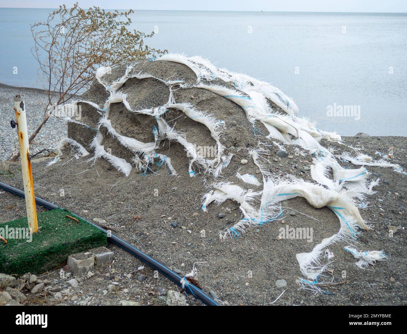 Cement chips in bags. Cement lumps. Building material on the seashore ...