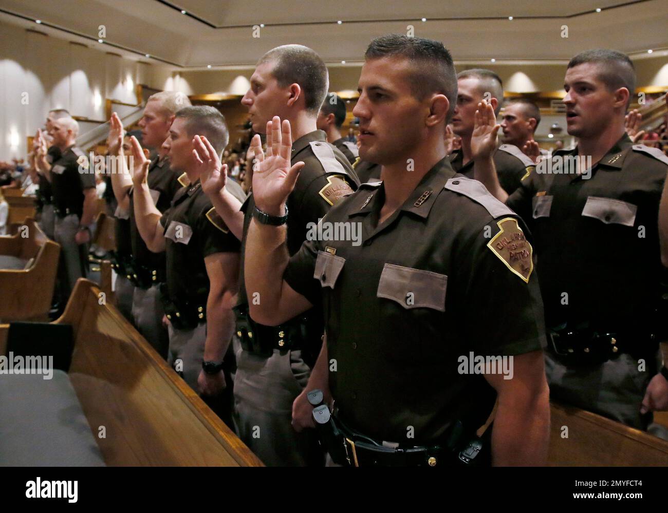 Newly graduated Oklahoma Highway Patrol Officer Garrett Henshaw raises ...