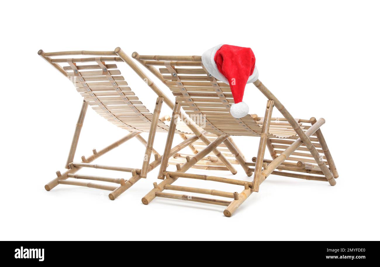 Wooden deck chairs and Santa Claus hat on white background. Christmas ...