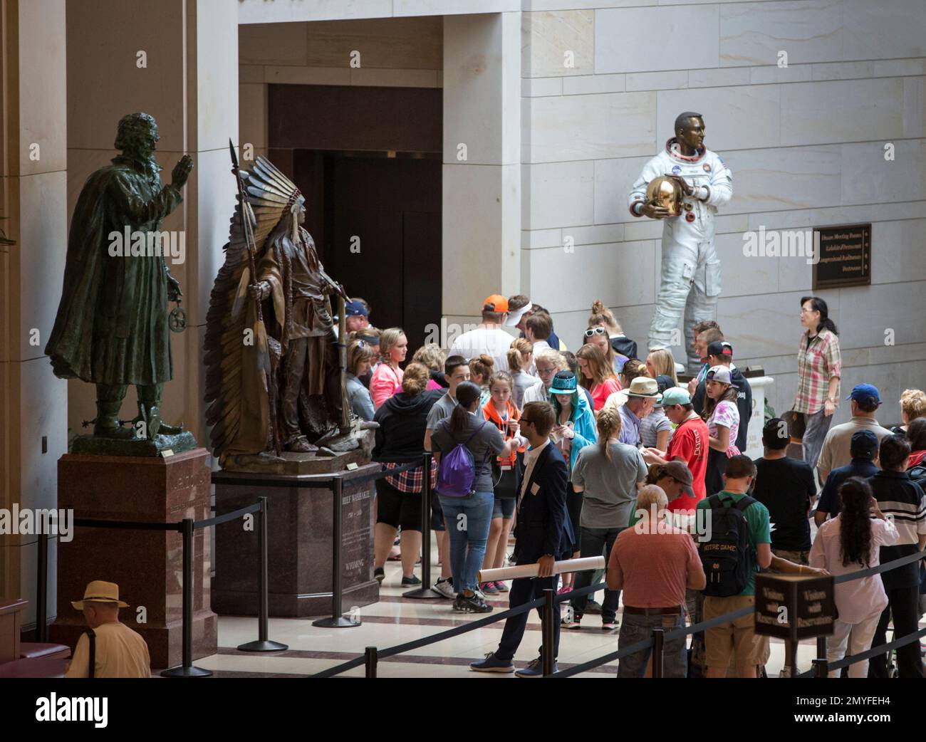 Tourists line up beneath statues of famous figures in American history ...
