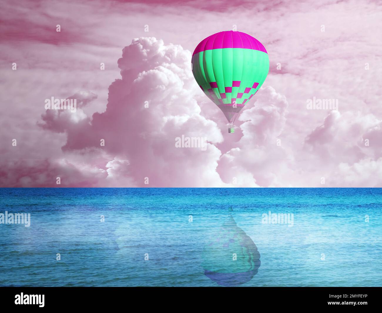 Dream world. Hot air balloon in pink cloudy sky over blue sea Stock ...