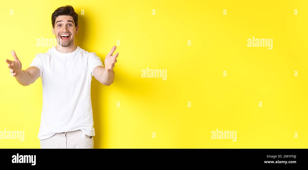 Excited handsome guy stretching hands forward, reaching for hug ...