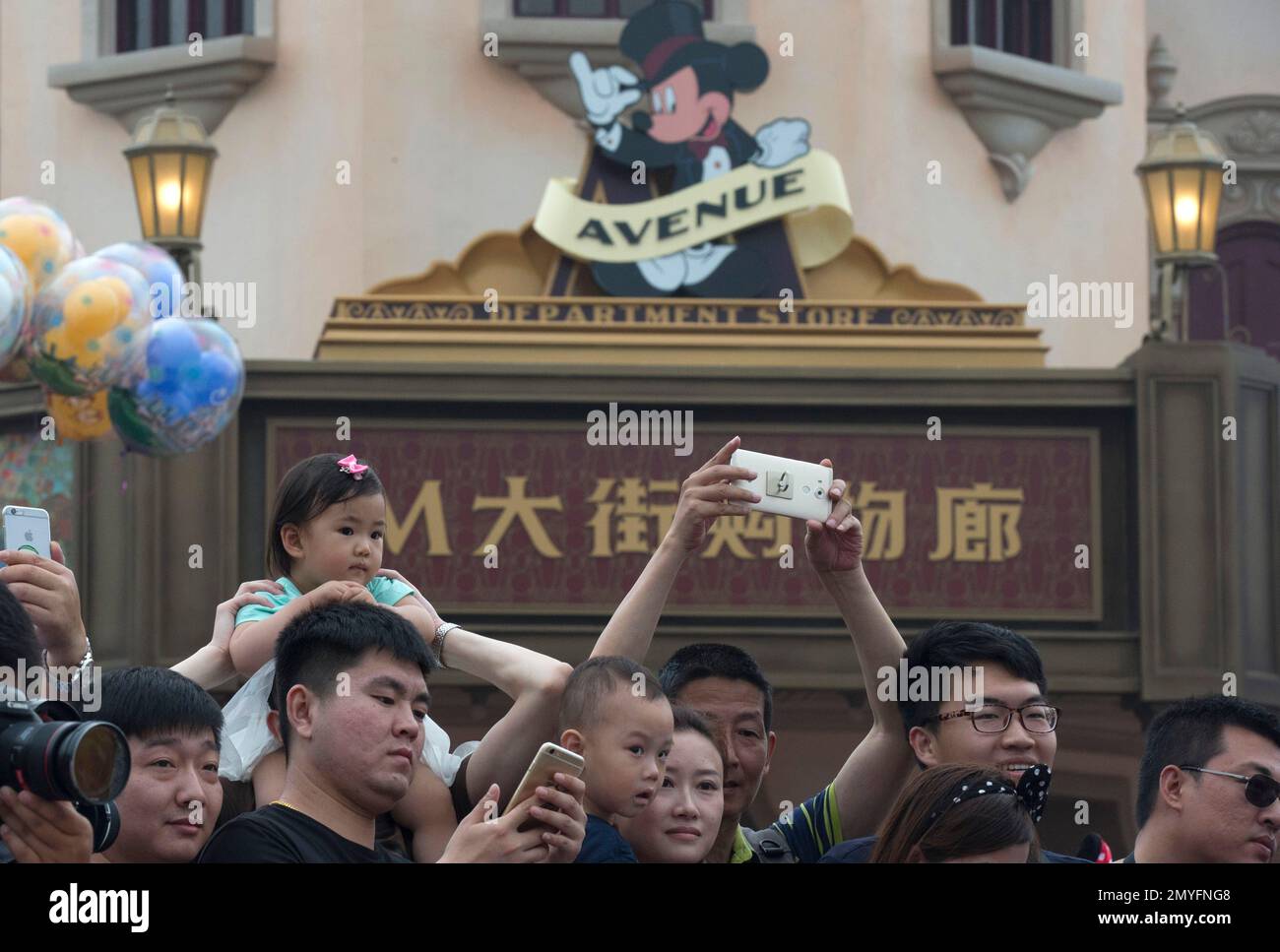 Visitors watch a performance on opening day of the Disney Resort in ...