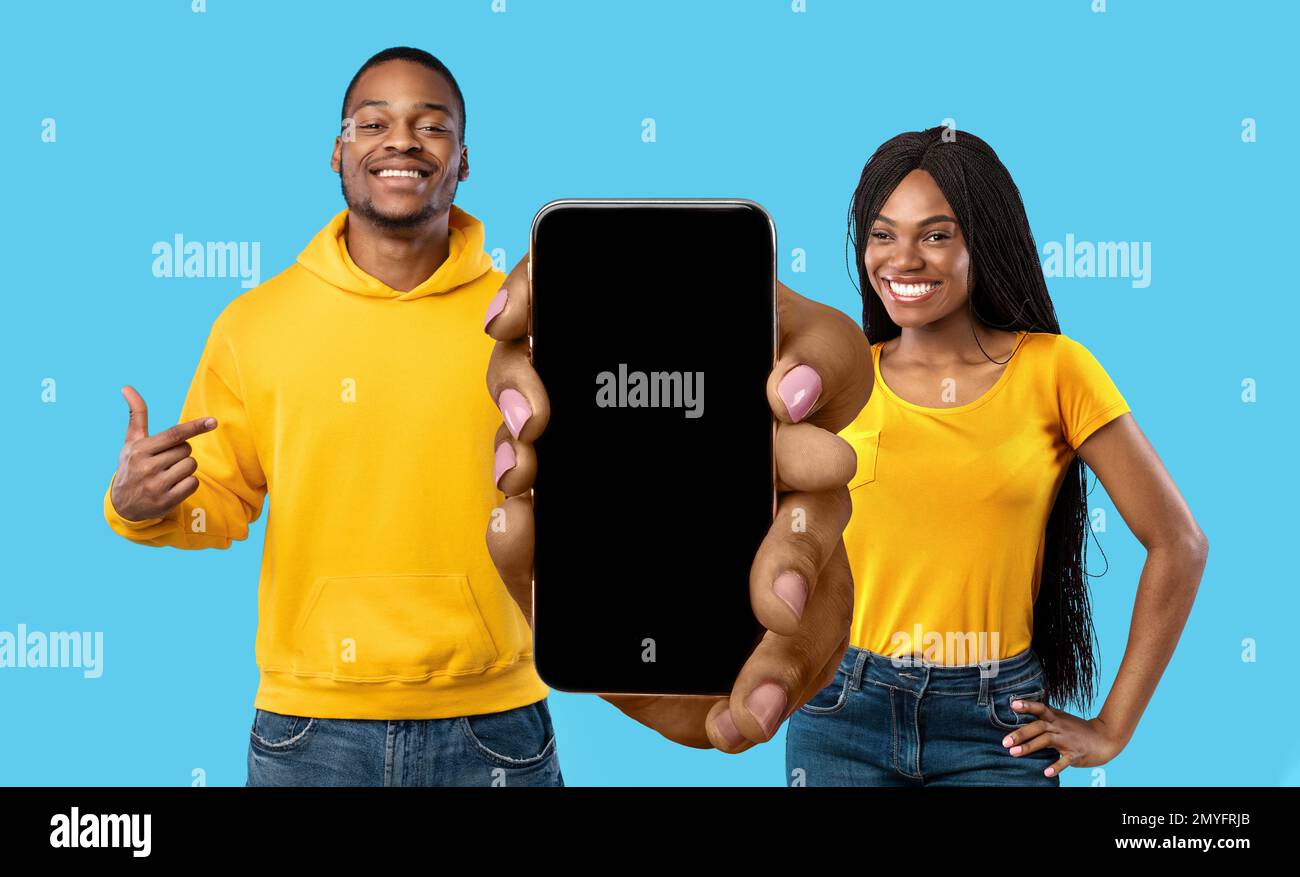 Mobile Ad. Smiling Black Man And Woman With Blank Smartphone In Hands ...