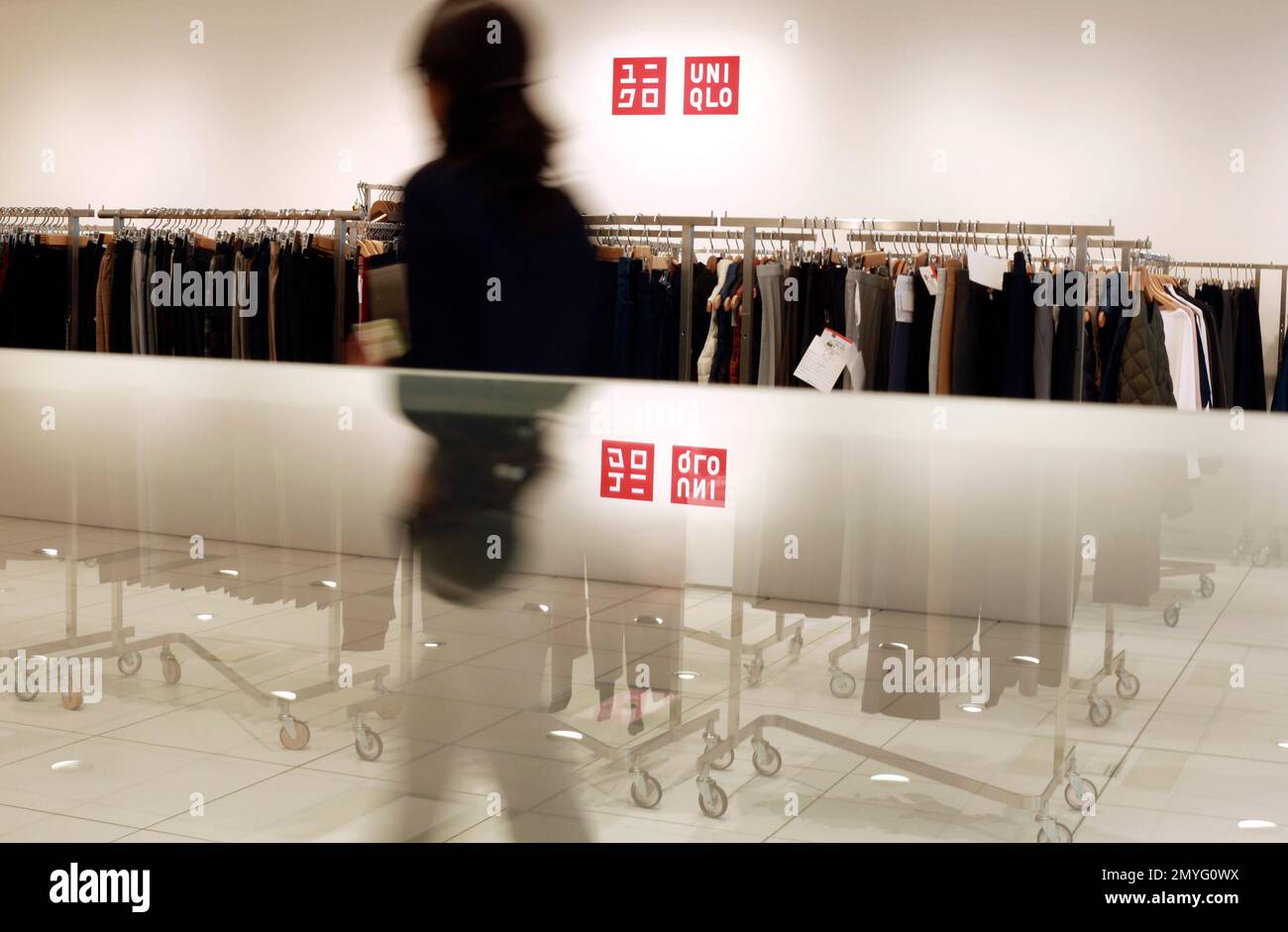 In this June 7, 2016 photo, a Uniqlo staff walks among clothing stored ...