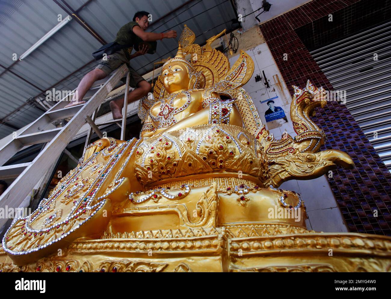 A Thai craftsman adds finishing touch on a Buddha statue in Bangkok ...