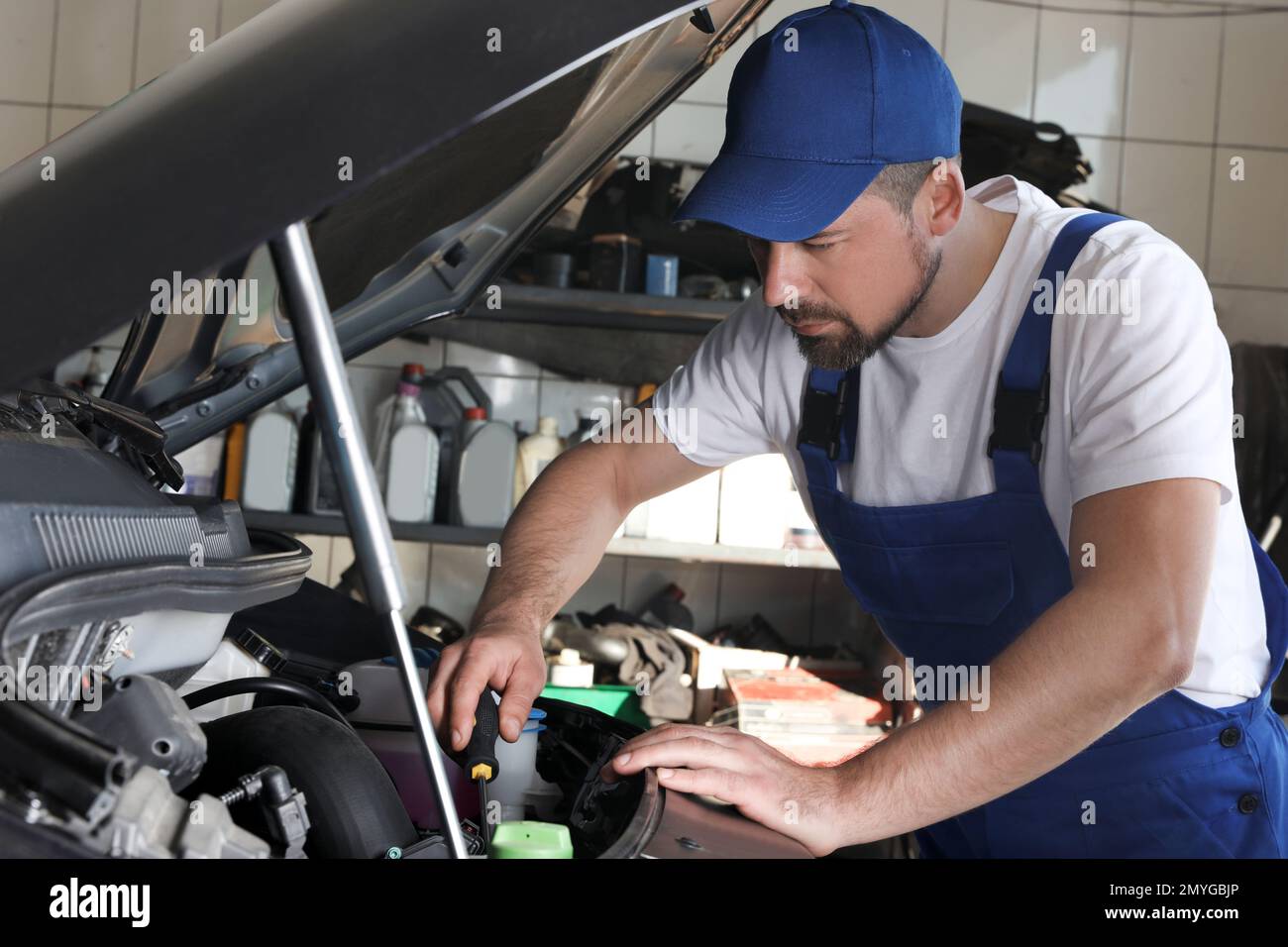Professional auto mechanic fixing modern car in service center Stock ...