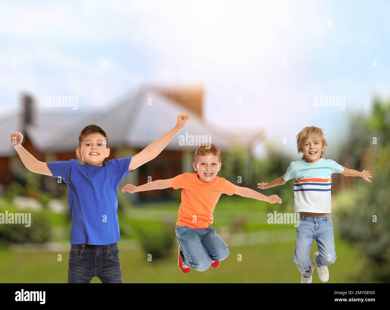 Happy boys jumping near house. School holidays Stock Photo - Alamy