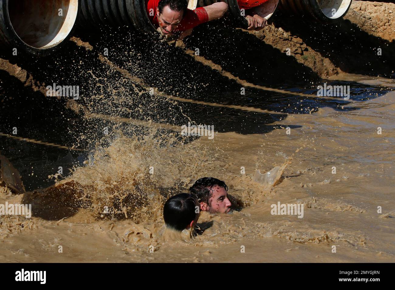 Participants swim in a mud pool during the Mud Day athletic event at El ...