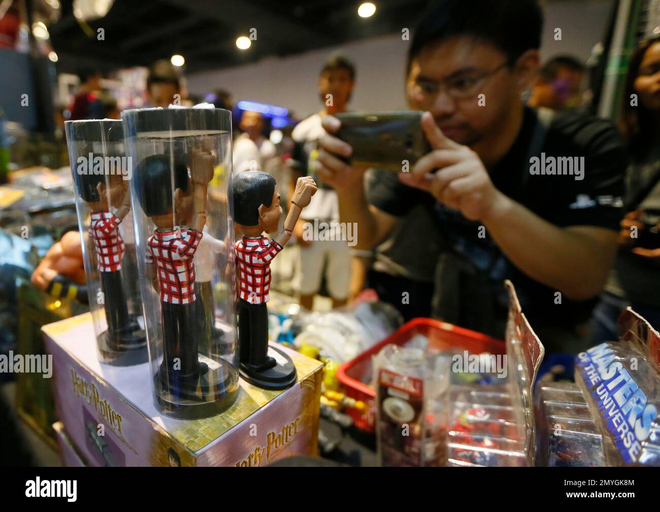 A customer takes a photo with his cellphone "Duterte toys" being sold ...