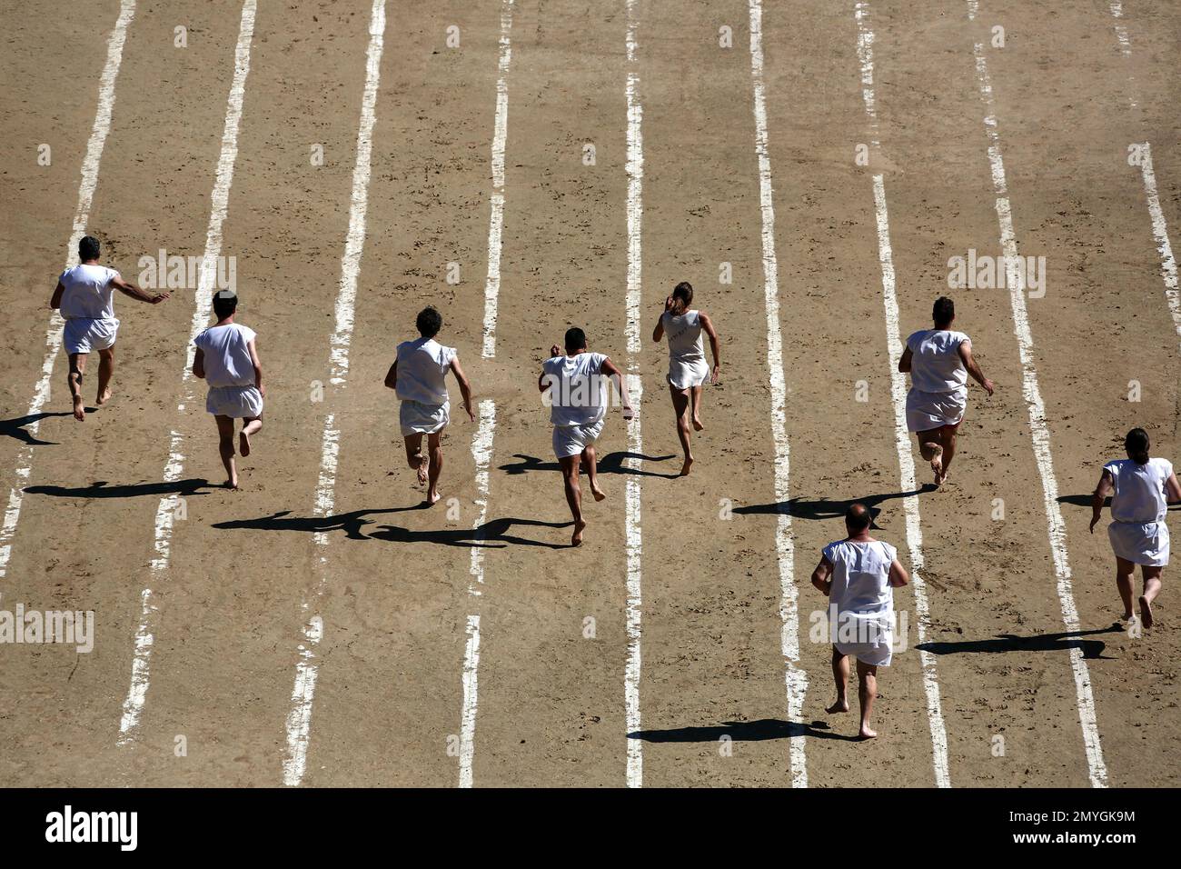 Barefoot runners wearing tunics take part in a footrace in the ancient ...
