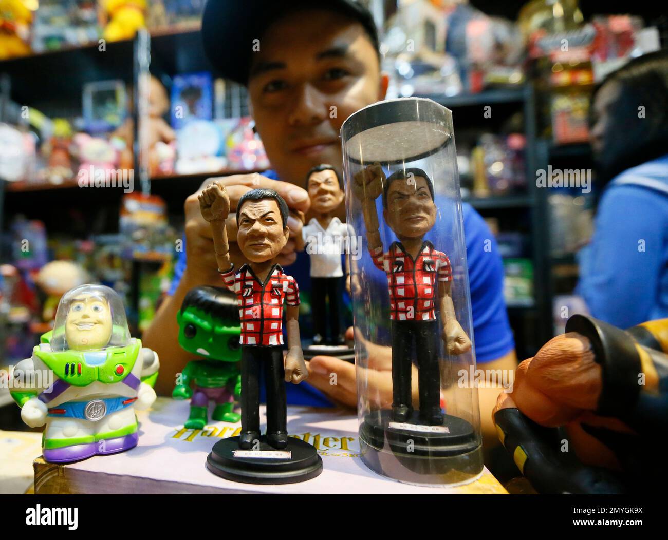 Dennis Mendoza, poses with "Duterte toys" he made and being sold at a ...