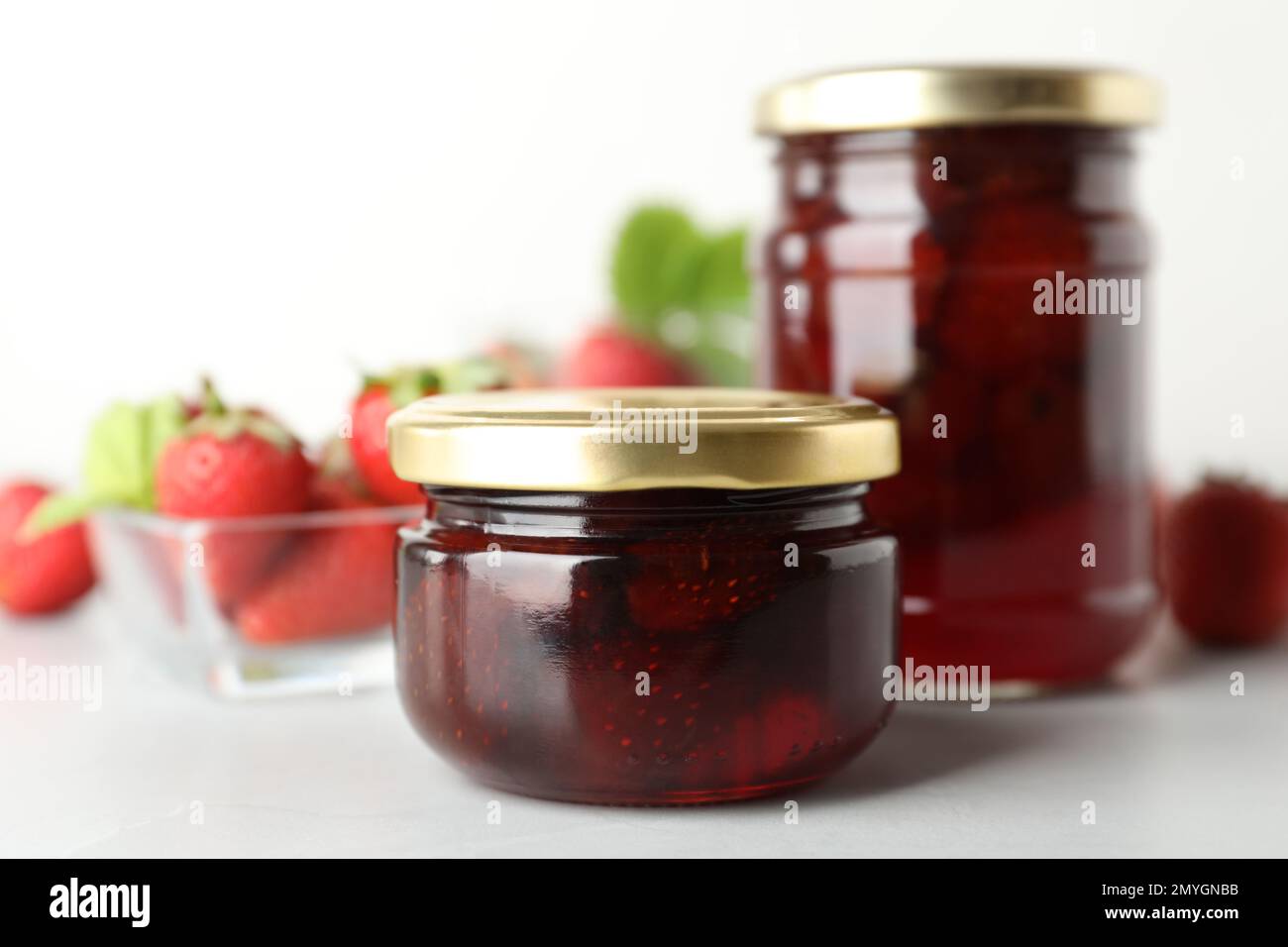 Delicious pickled strawberry jam and fresh berries on light table Stock ...