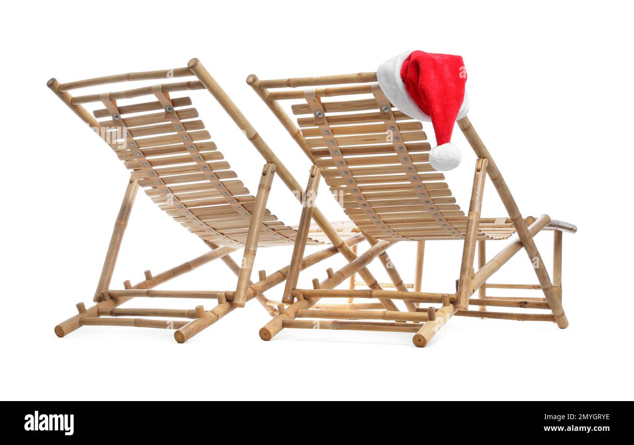 Wooden deck chairs and Santa Claus hat on white background. Christmas ...