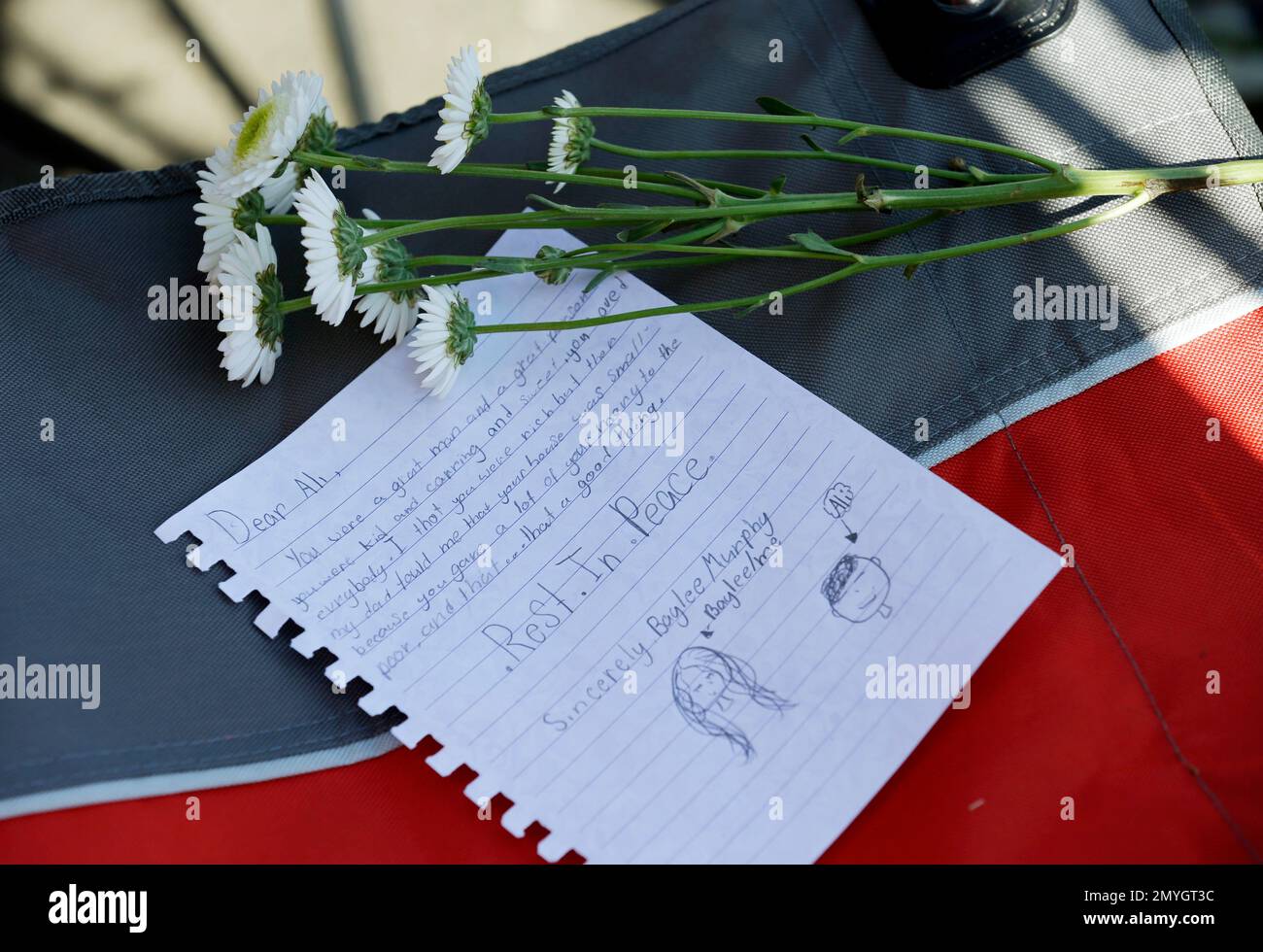 A letter of tribute and flowers sit on a chair as fans await the ...