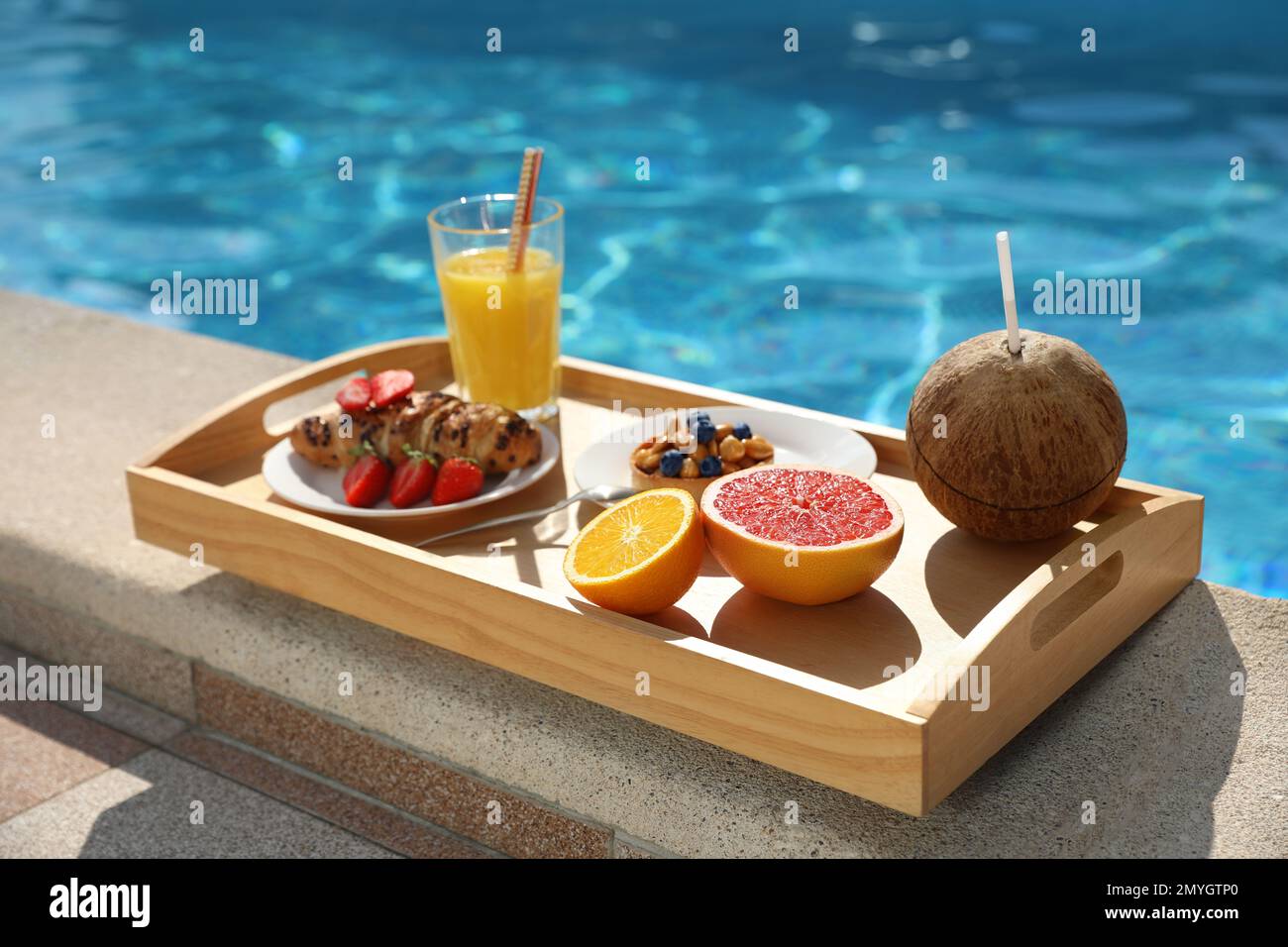 Tray with delicious breakfast near swimming pool Stock Photo - Alamy