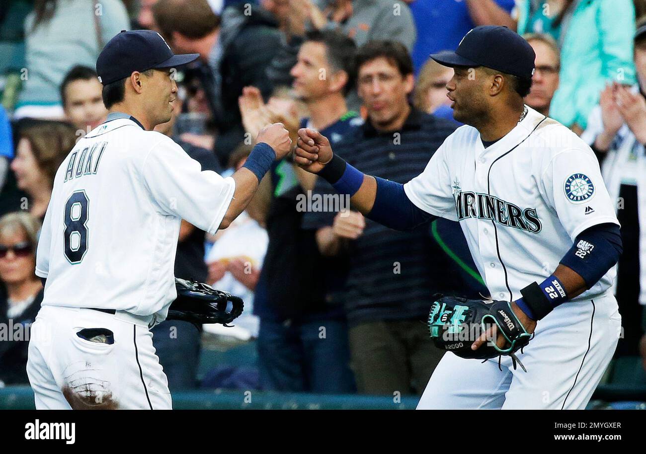 Seattle Mariners left fielder Norichika Aoki, left, is greeted at the ...