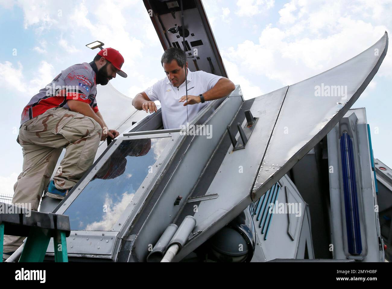 Robosaurus crew chief Shawn Pacheco, left on ladder, instructs IndyCar ...
