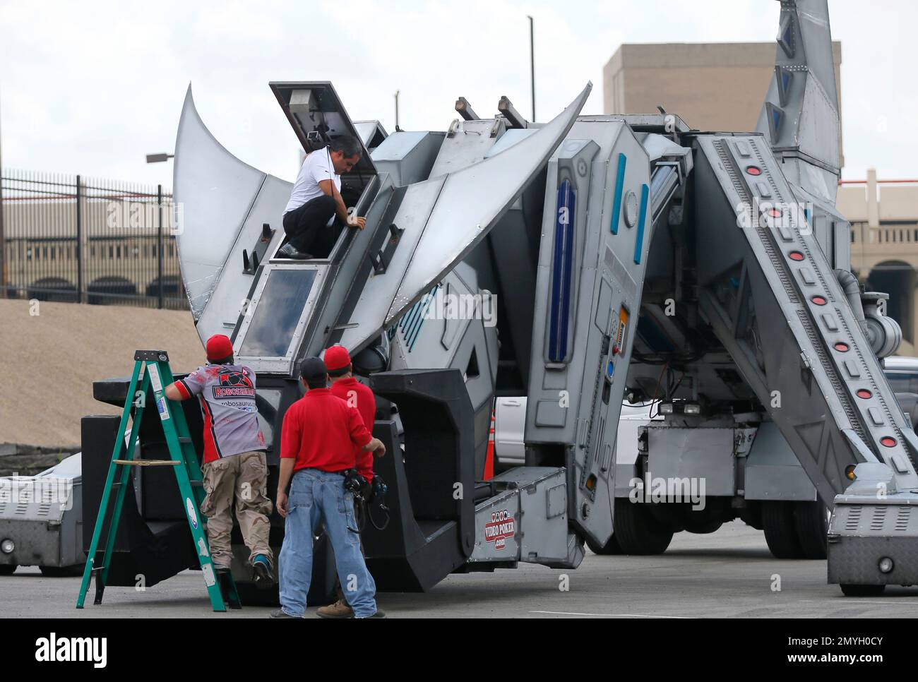 Robosaurus crew chief Shawn Pacheco, on ladder, instructs IndyCar ...