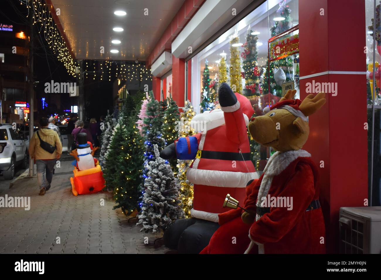 Christmas decorations fill the sidewalk in front of a store in Erbil ...