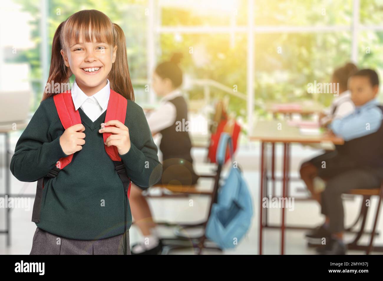 Happy girl with backpack in school classroom Stock Photo - Alamy