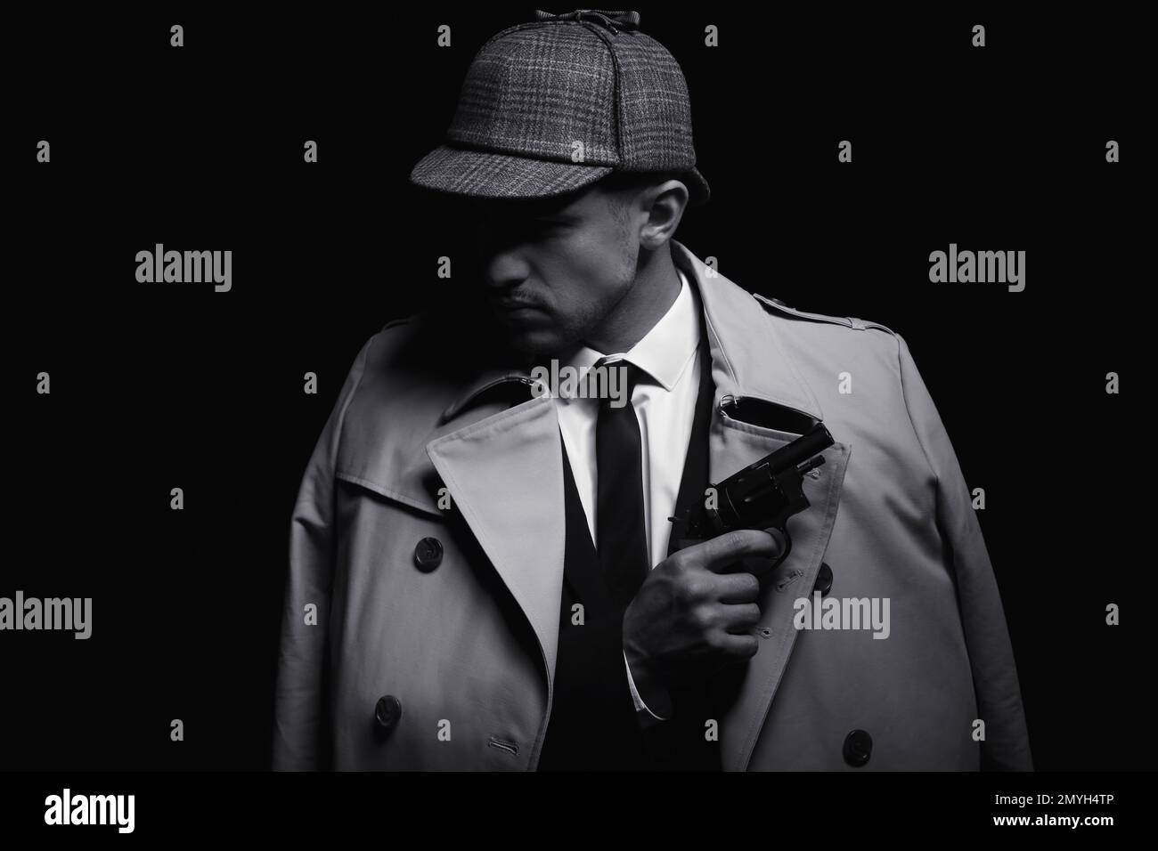 Old fashioned detective with revolver on dark background, black and ...