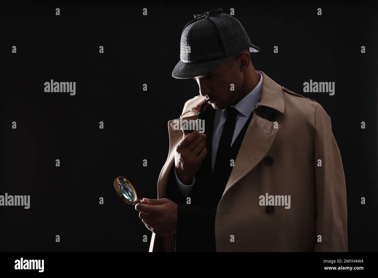 Old fashioned detective with smoking pipe and magnifying glass on dark ...