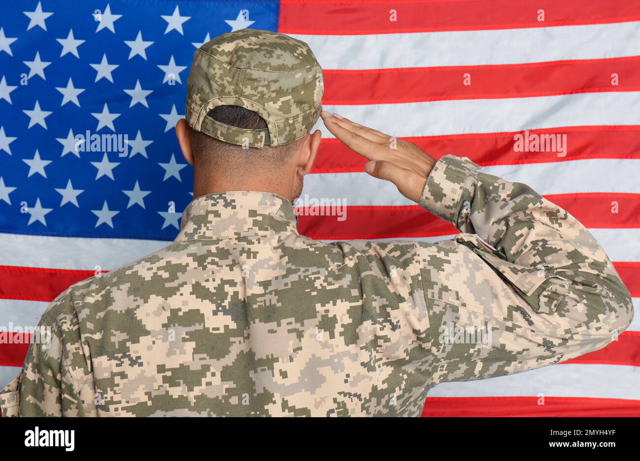 Soldier in uniform against United states of America flag, back view ...