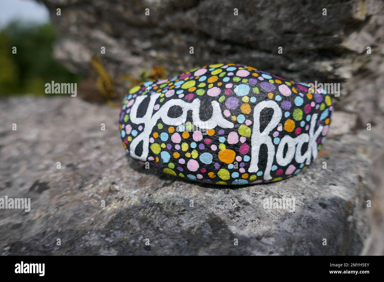 Encouraging and uplifting message painted on kindness rock on top of ...