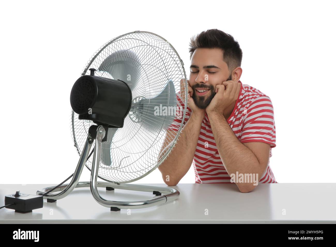 Man enjoying air flow from fan on white background. Summer heat Stock ...