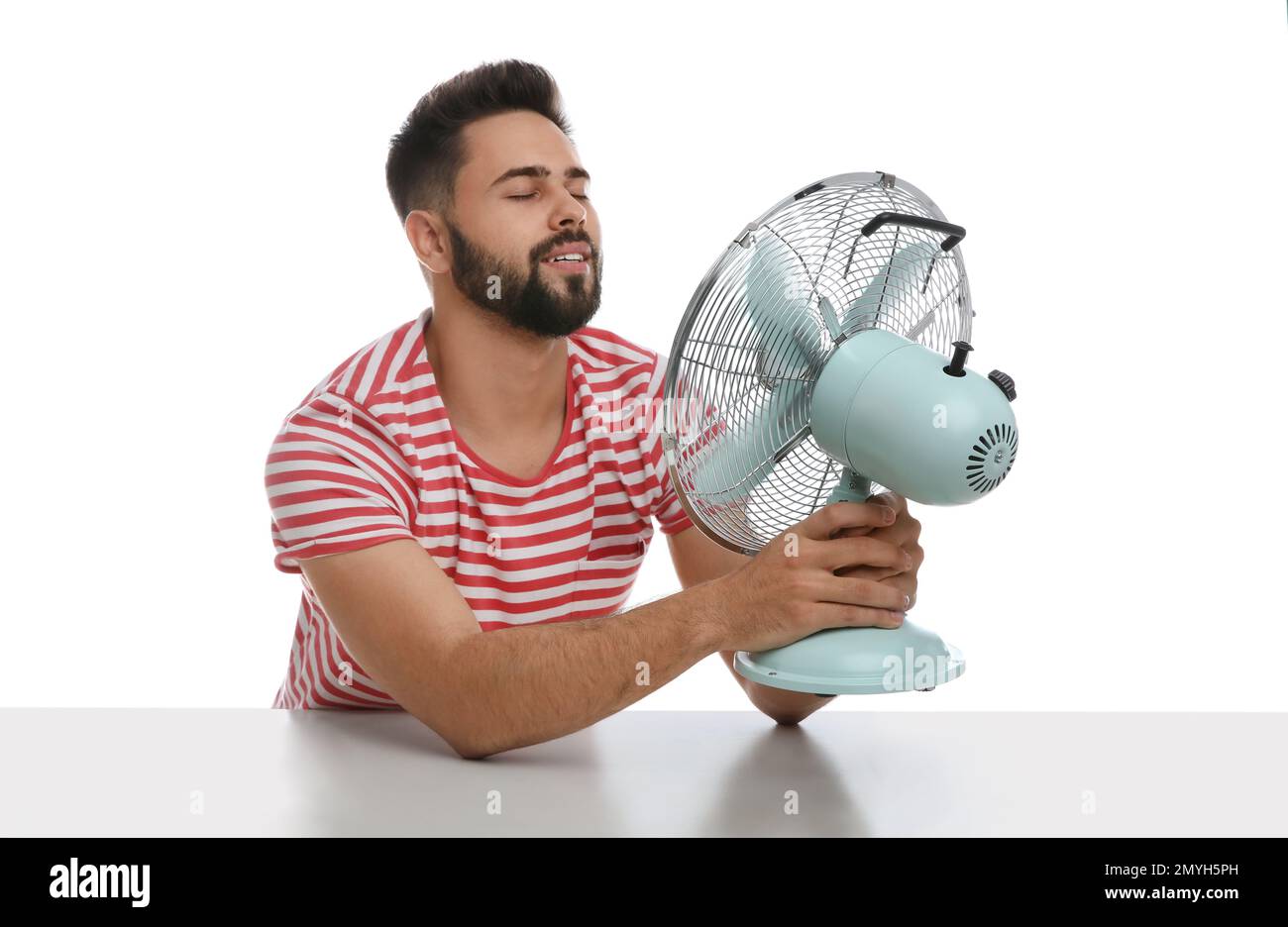 Man enjoying air flow from fan on white background. Summer heat Stock ...