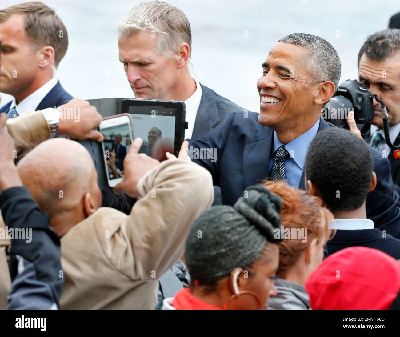 President Barack Obama laughs as a small crowd of well-wishers try to ...