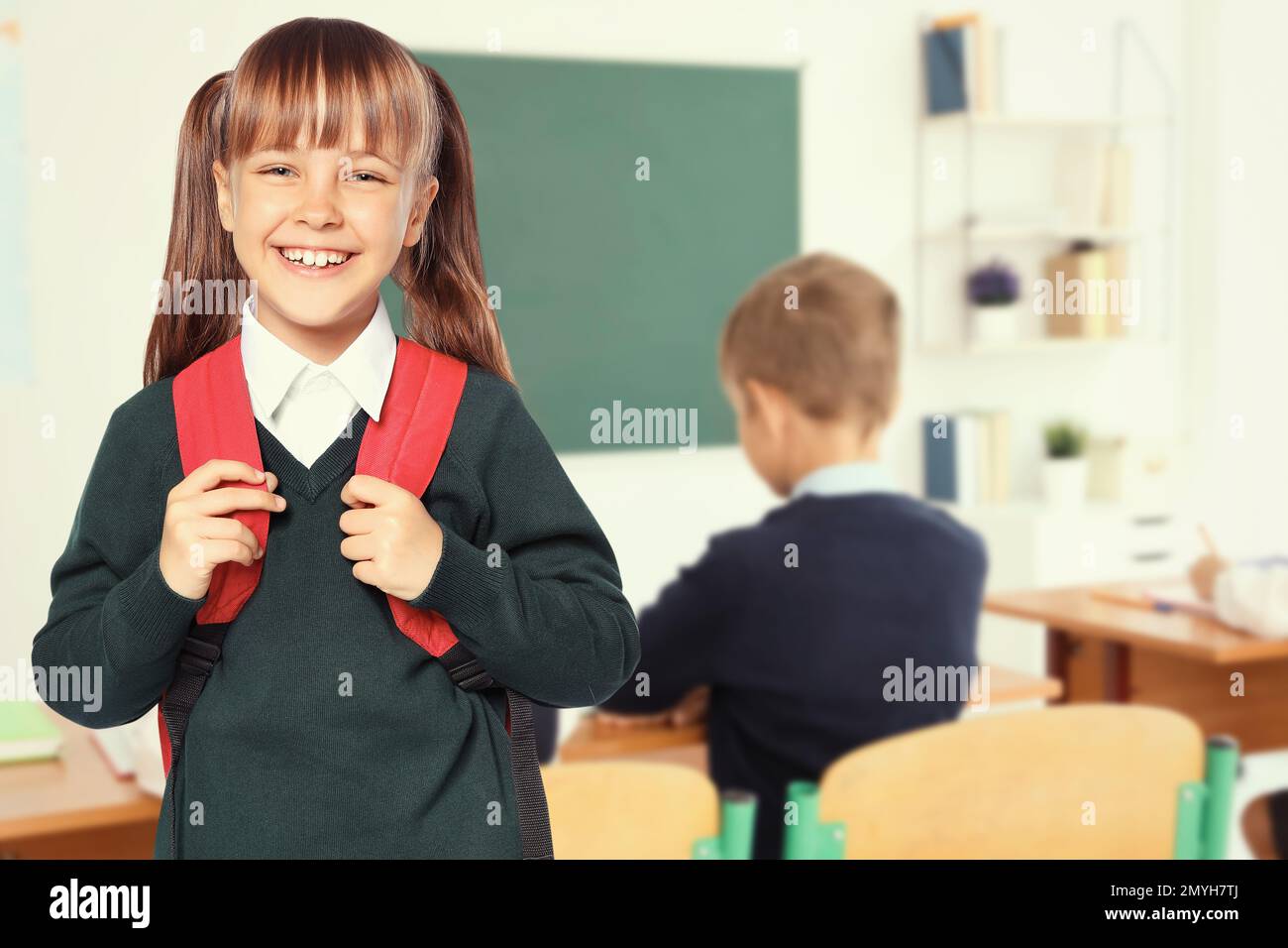 Happy girl with backpack in school classroom Stock Photo - Alamy