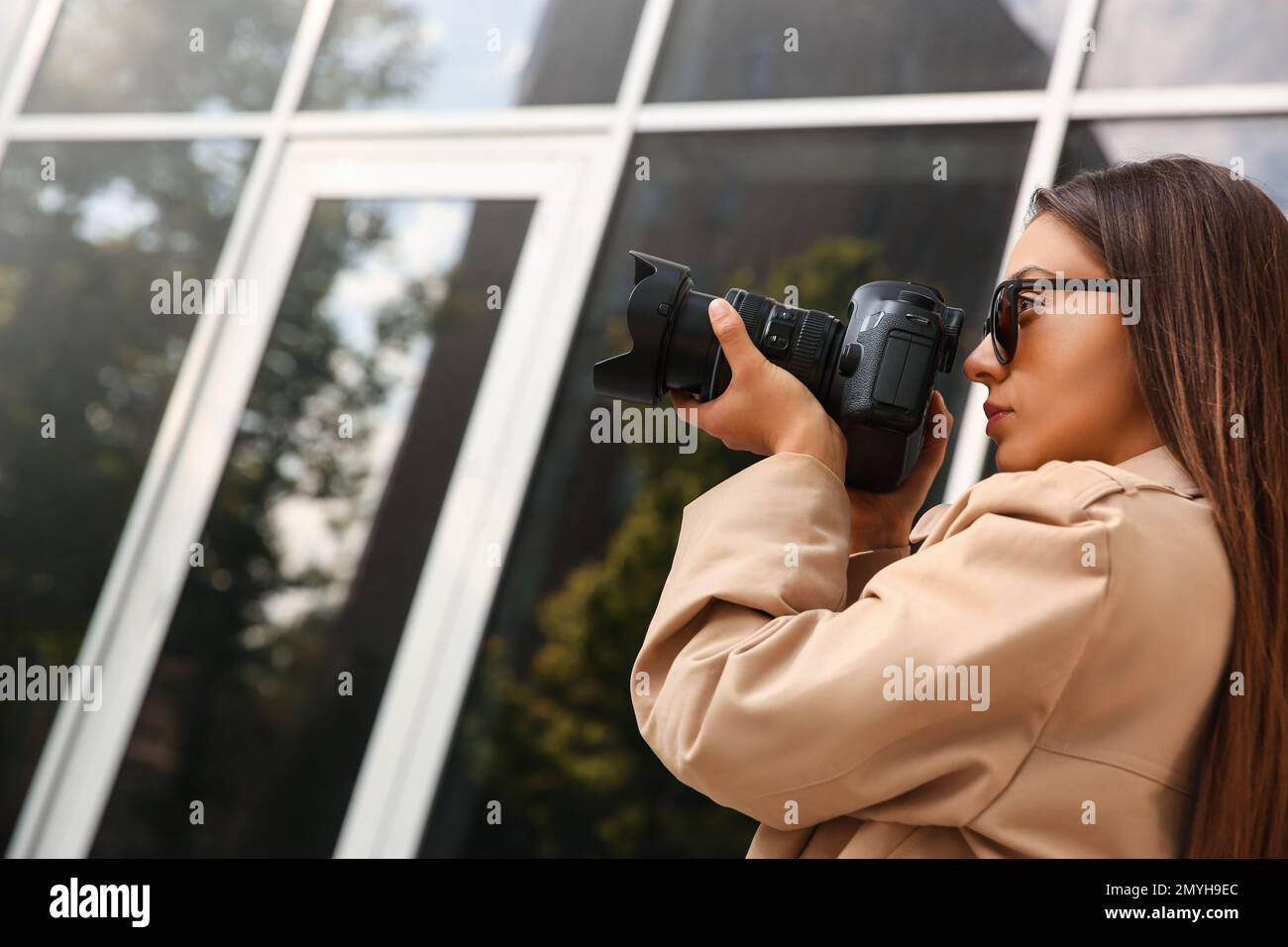 Private detective with camera spying near building on city street Stock ...