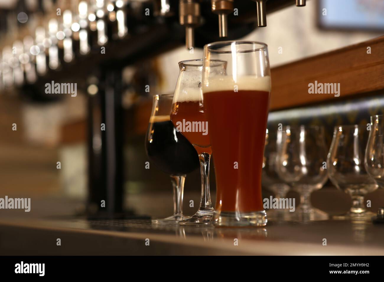 Different beers in glasses on bar counter Stock Photo - Alamy