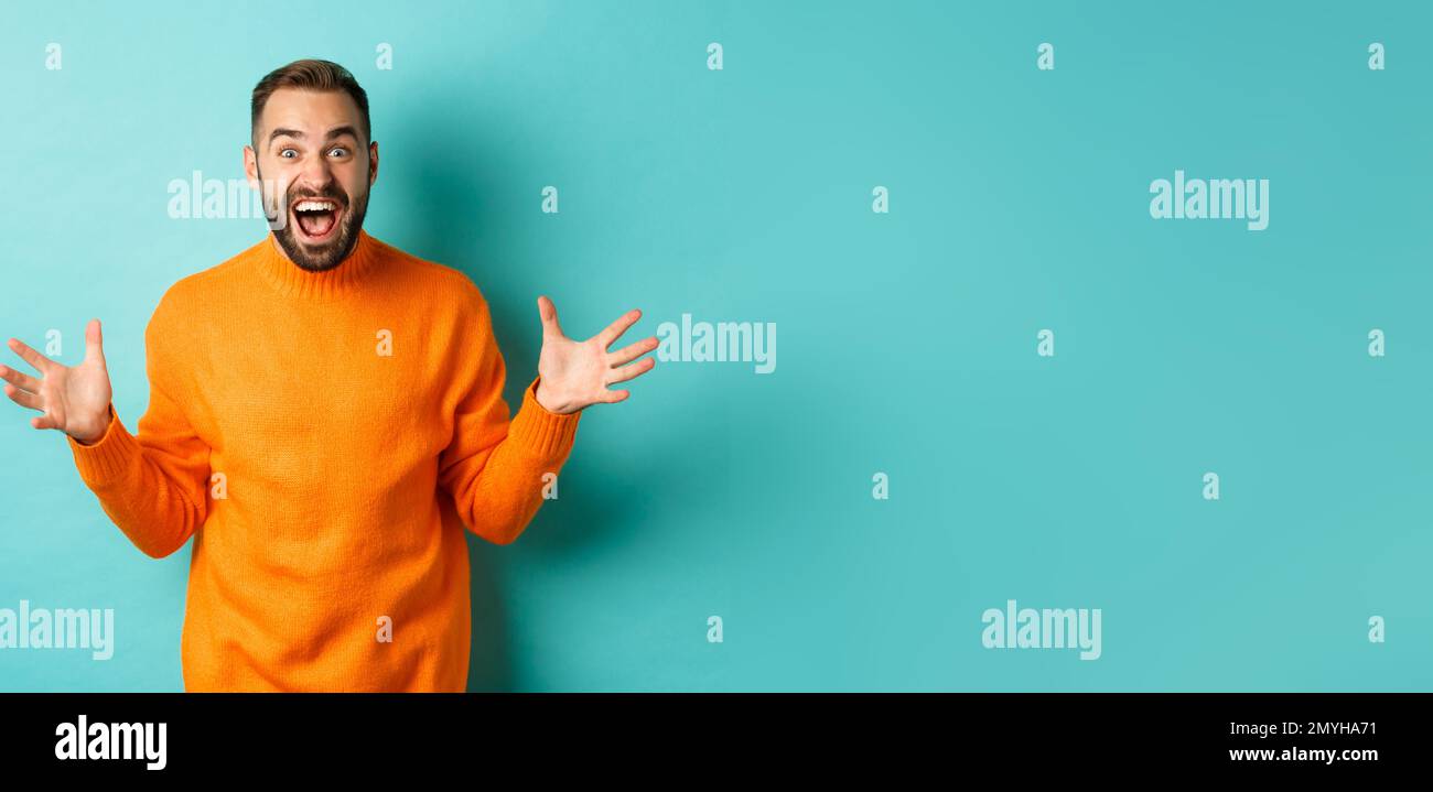 Image of happy and excited man announce big news, spread hands and ...