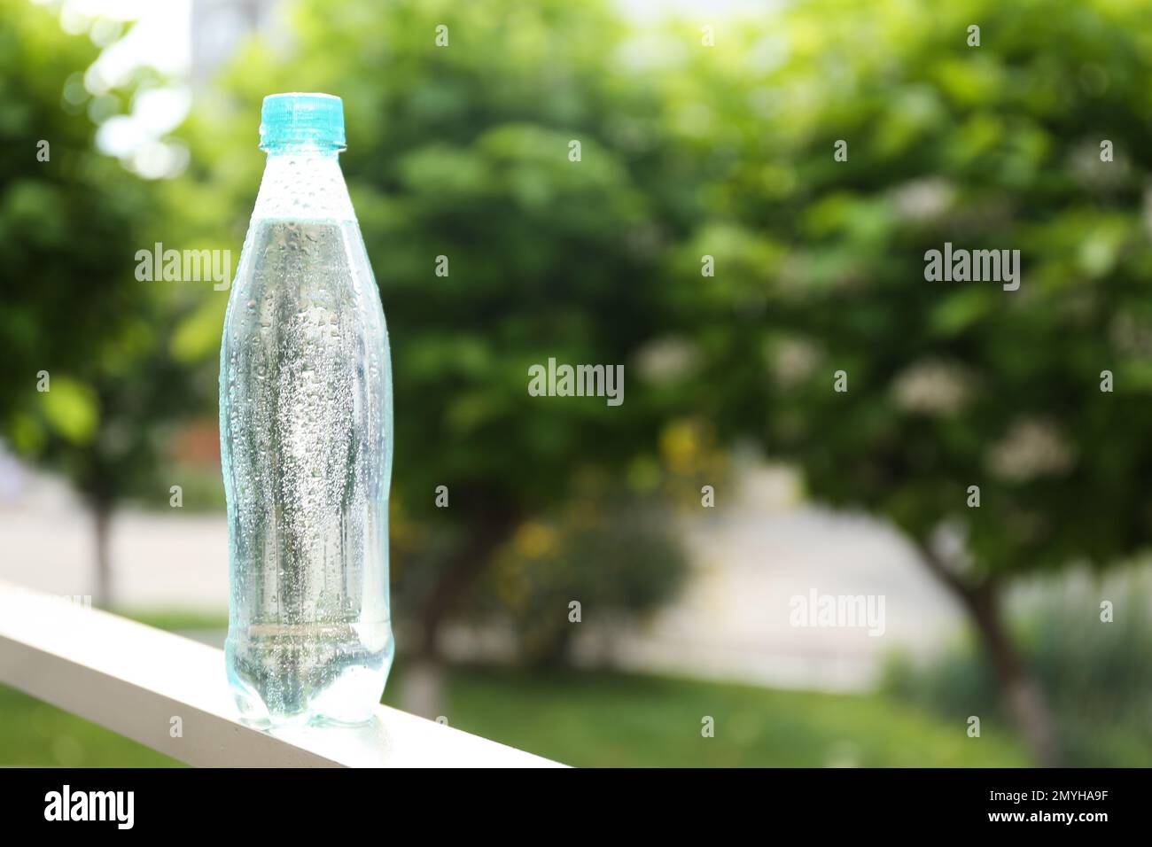Plastic bottle of cold pure water outdoors. Space for text Stock Photo ...