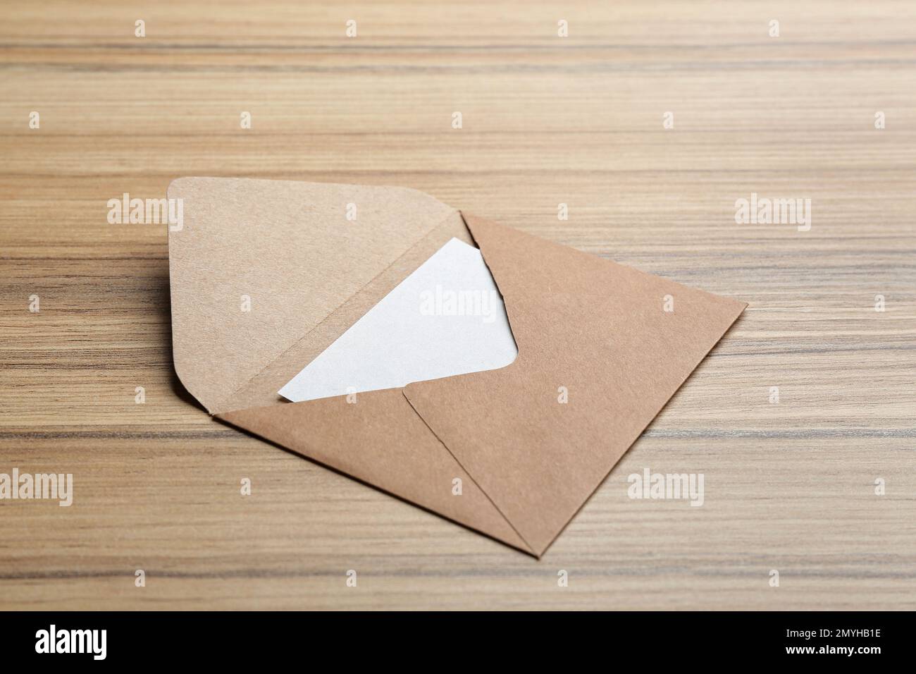 Brown paper envelope on wooden background. Mail service Stock Photo - Alamy