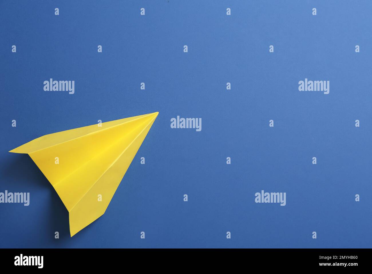 Yellow paper plane on blue background, top view. Space for text Stock ...