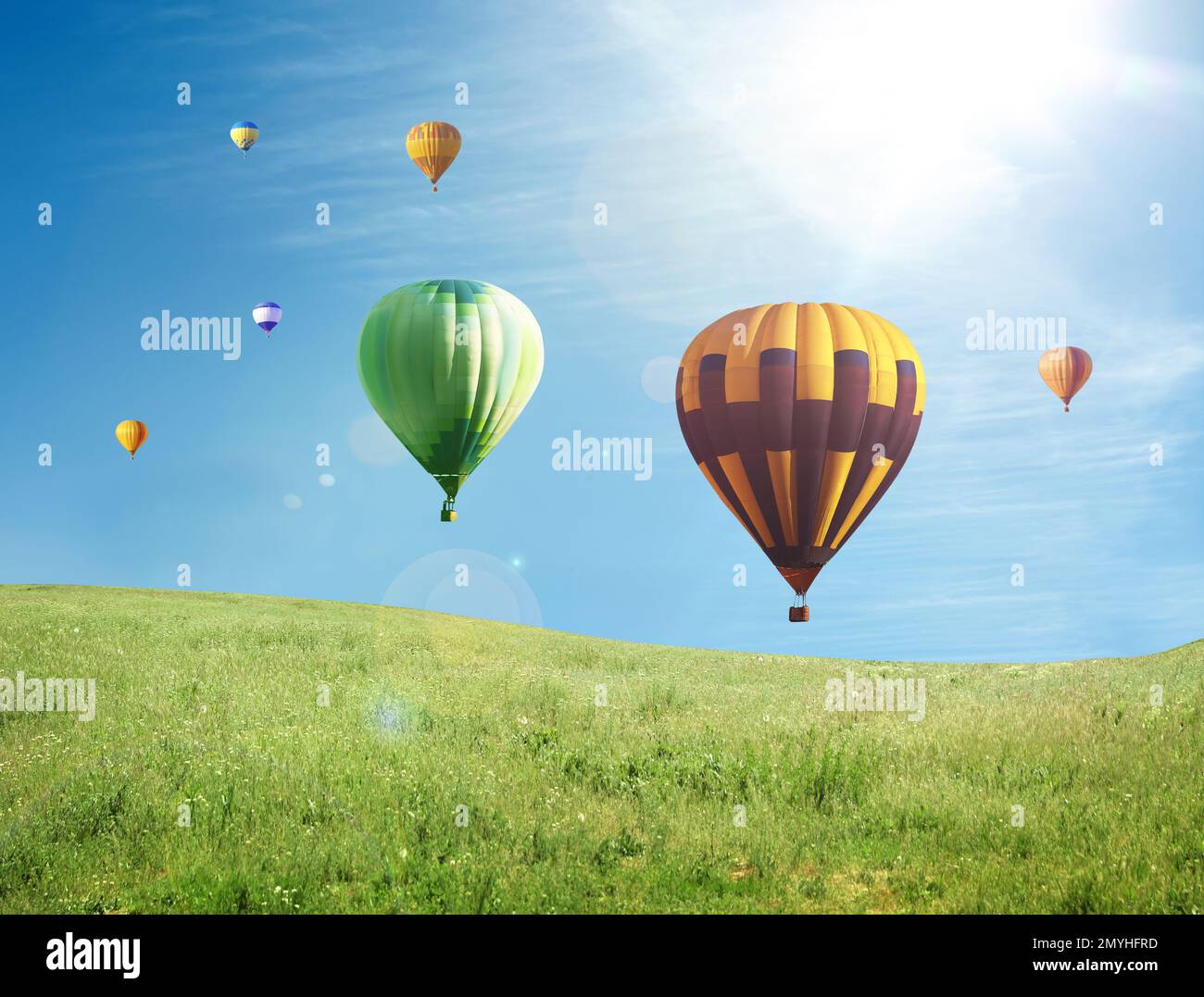 Dream world. Hot air balloons in blue sky over green meadow Stock Photo ...