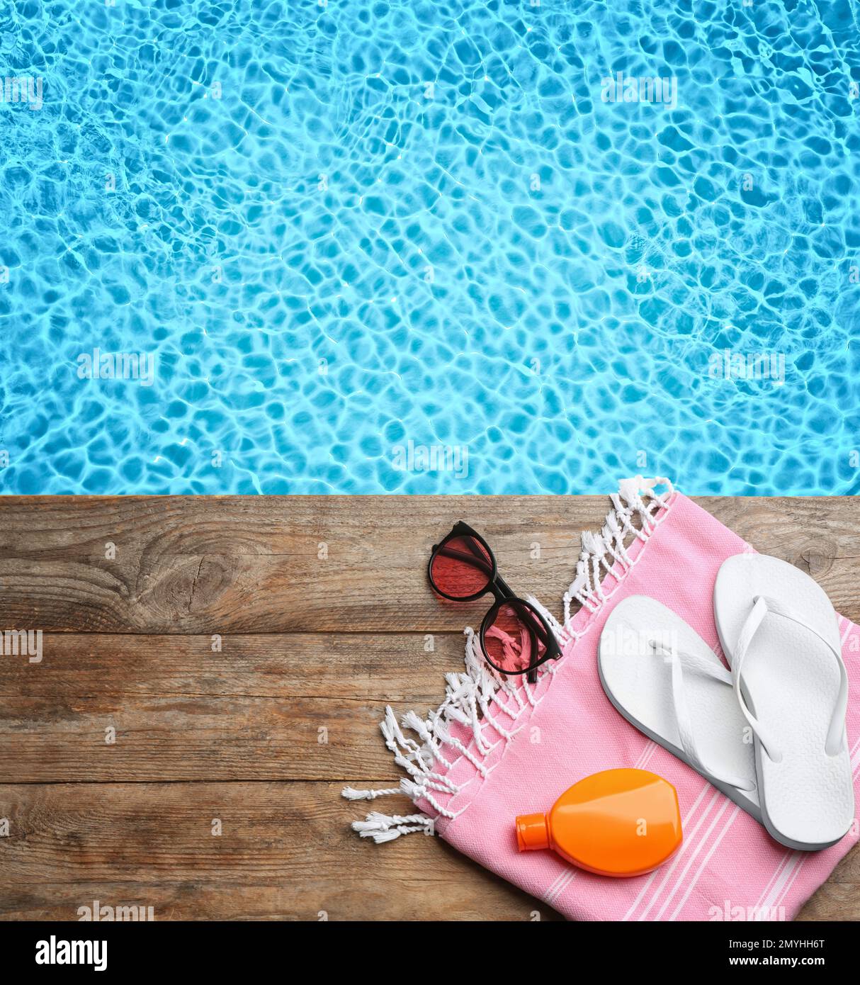Beach accessories on wooden deck near swimming pool, flat lay. Space ...