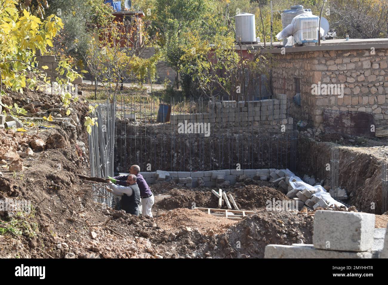 Two men working on the foundation of a house being built in a Northern ...