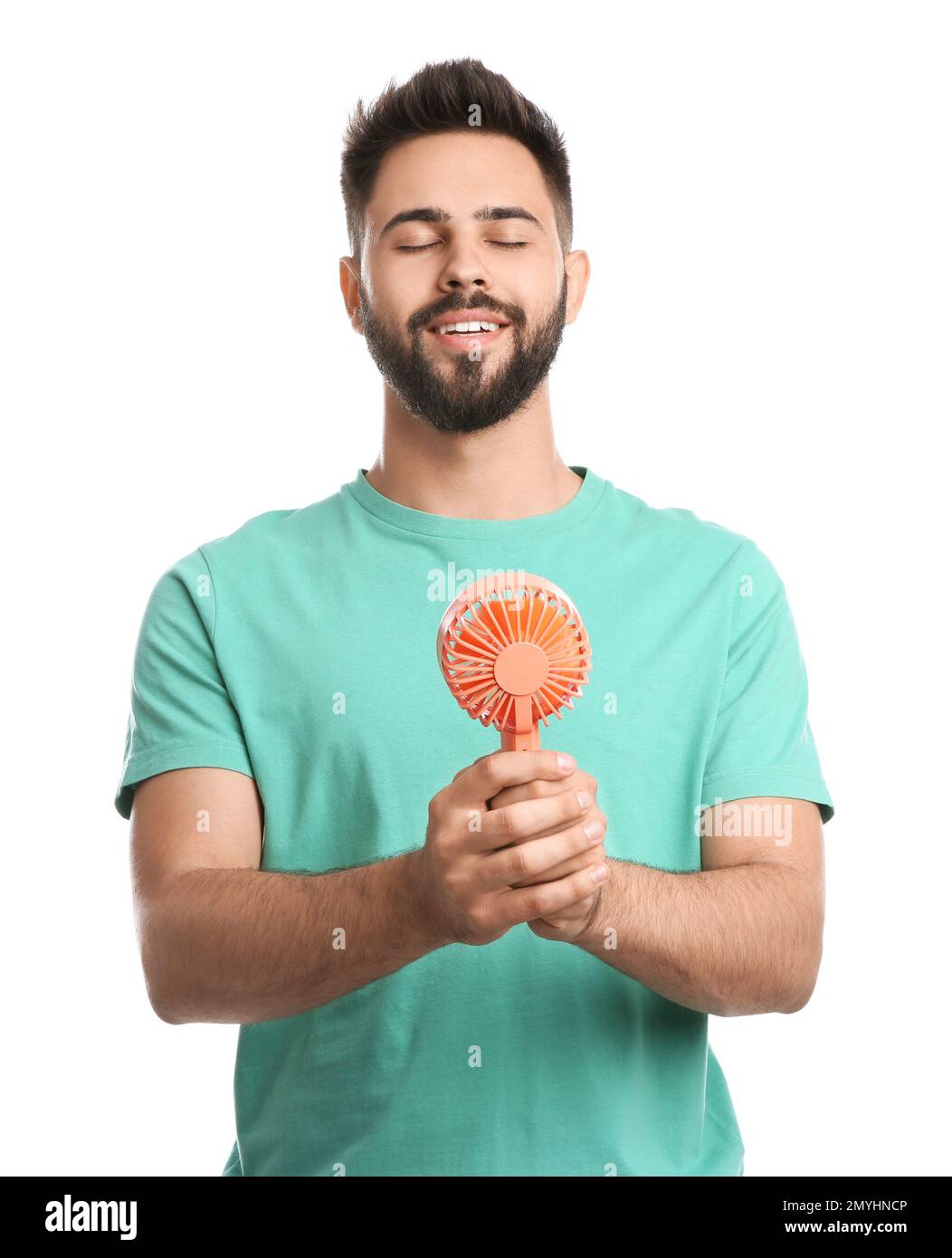 Man enjoying air flow from portable fan on white background. Summer ...