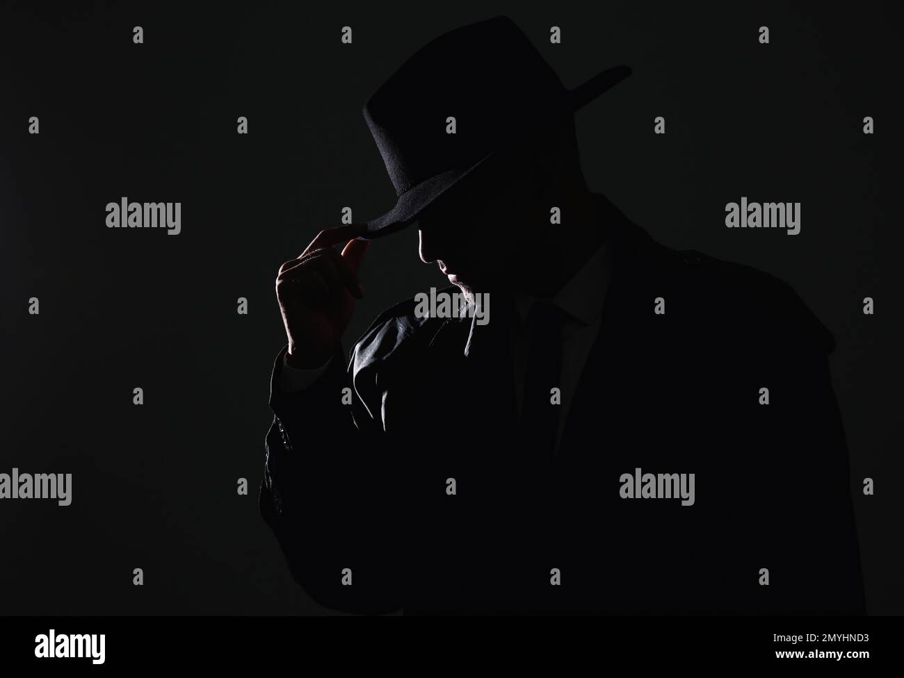 Old fashioned detective in hat on dark background Stock Photo - Alamy