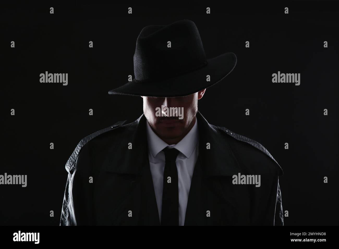 Old fashioned detective in hat on dark background Stock Photo - Alamy