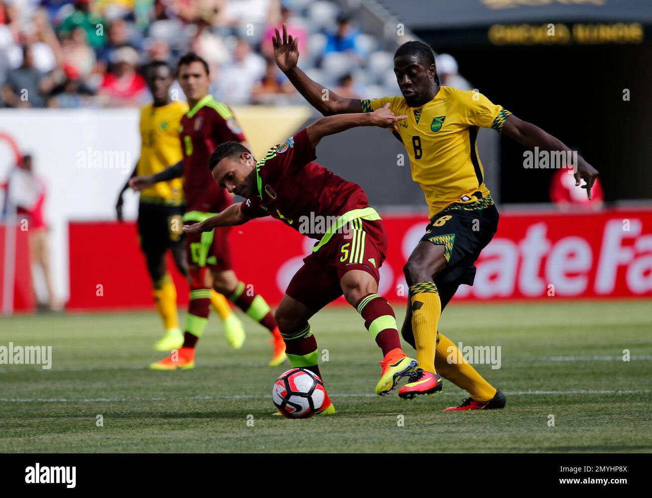 Venezuela's Arquimedes Figuera (5), left, is challenged by Jamaica's ...