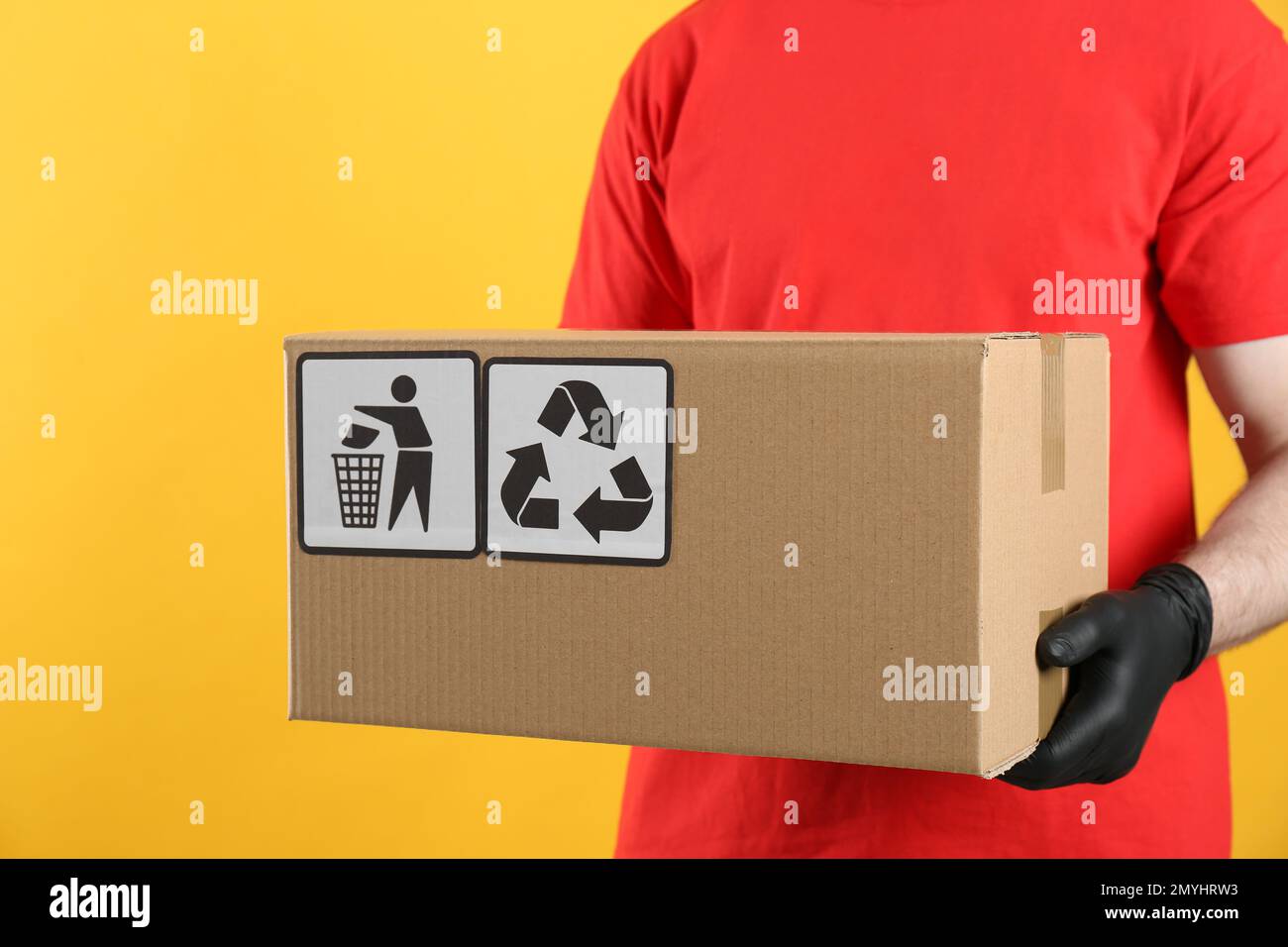 Courier holding cardboard box with different packaging symbols on ...