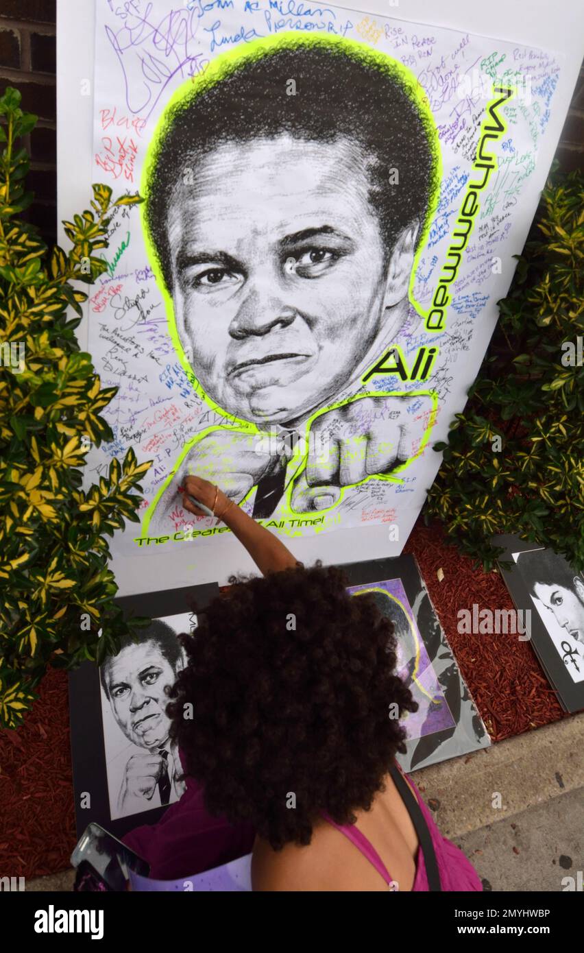 A woman signs a mural of boxing great Muhammad Ali Saturday, June 4 ...