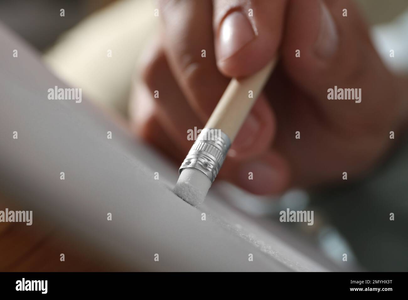 Man correcting picture on paper with pencil eraser, closeup Stock Photo ...