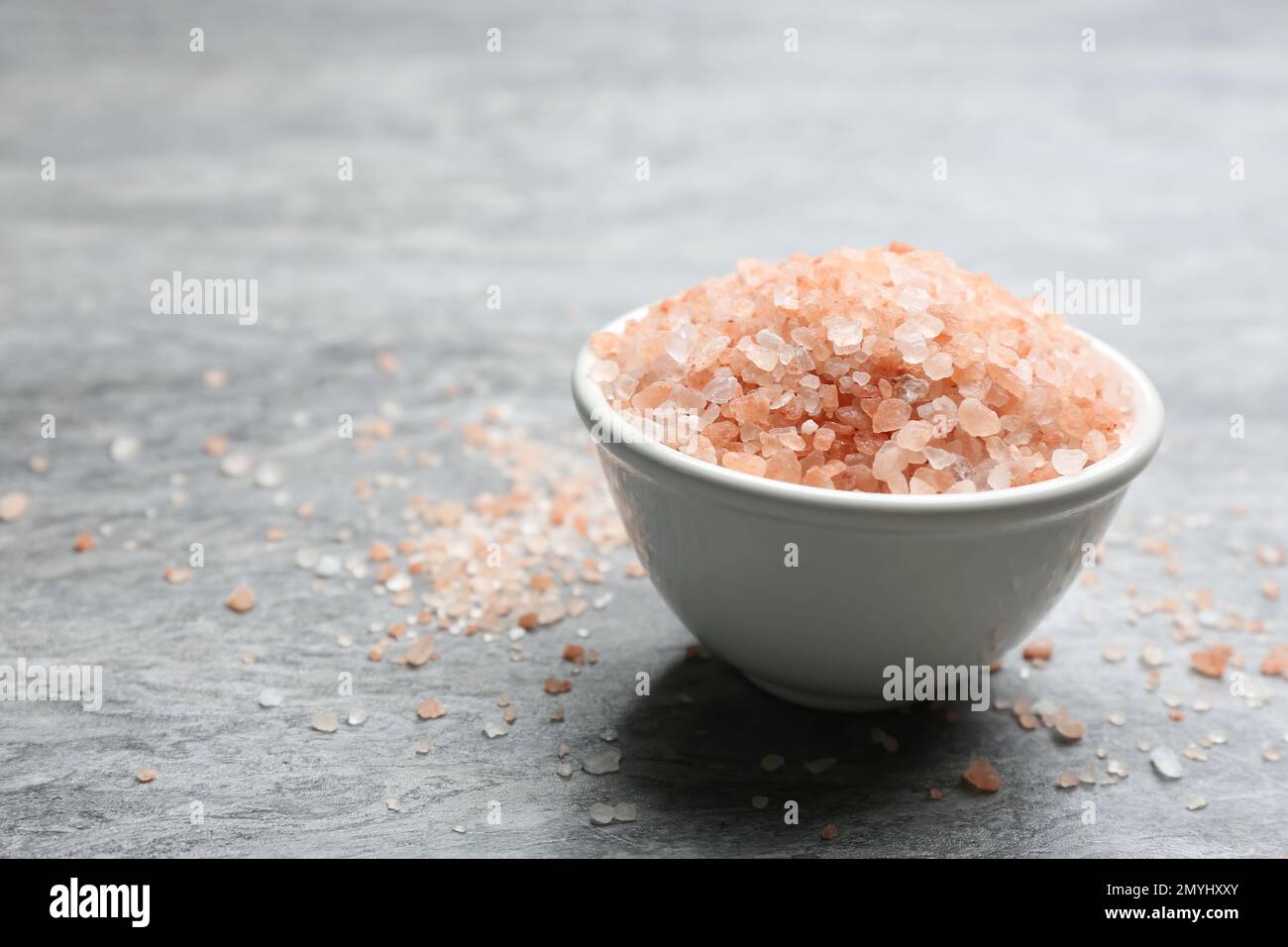 Pink himalayan salt on grey table, closeup. Space for text Stock Photo ...